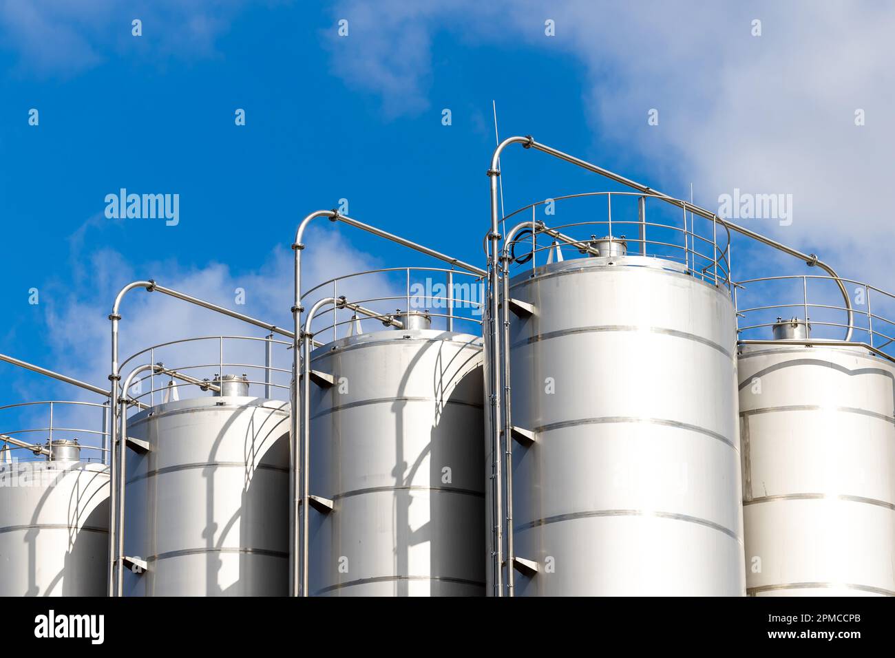 Stainless steel silos against the blue sky. Warehouses for storage of ...