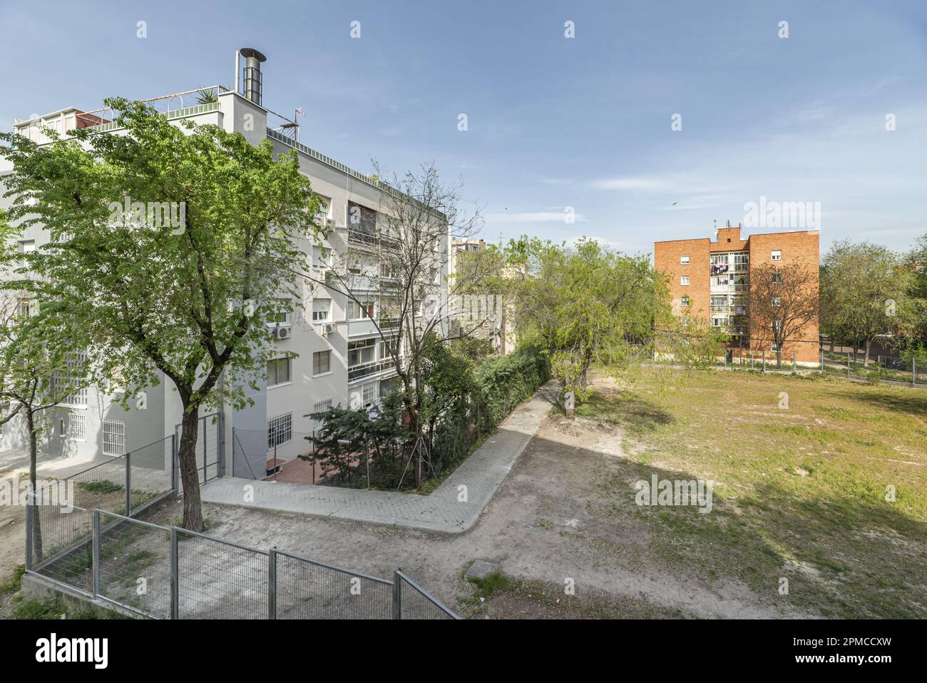 Facades of urban residential houses with a large solar void with grass ...