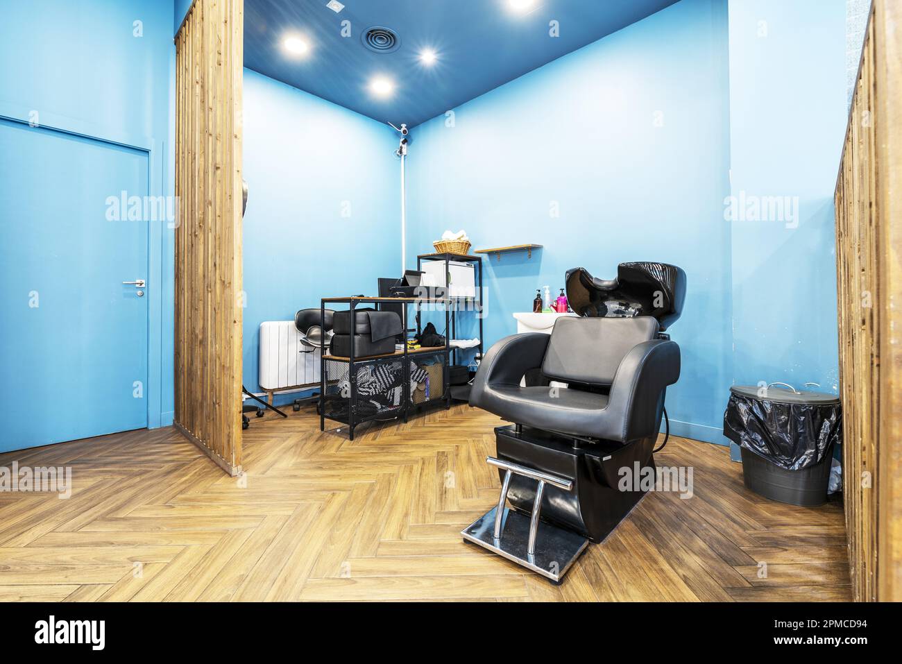 Corner of a hairdressing salon with a black armchair with a porcelain ...
