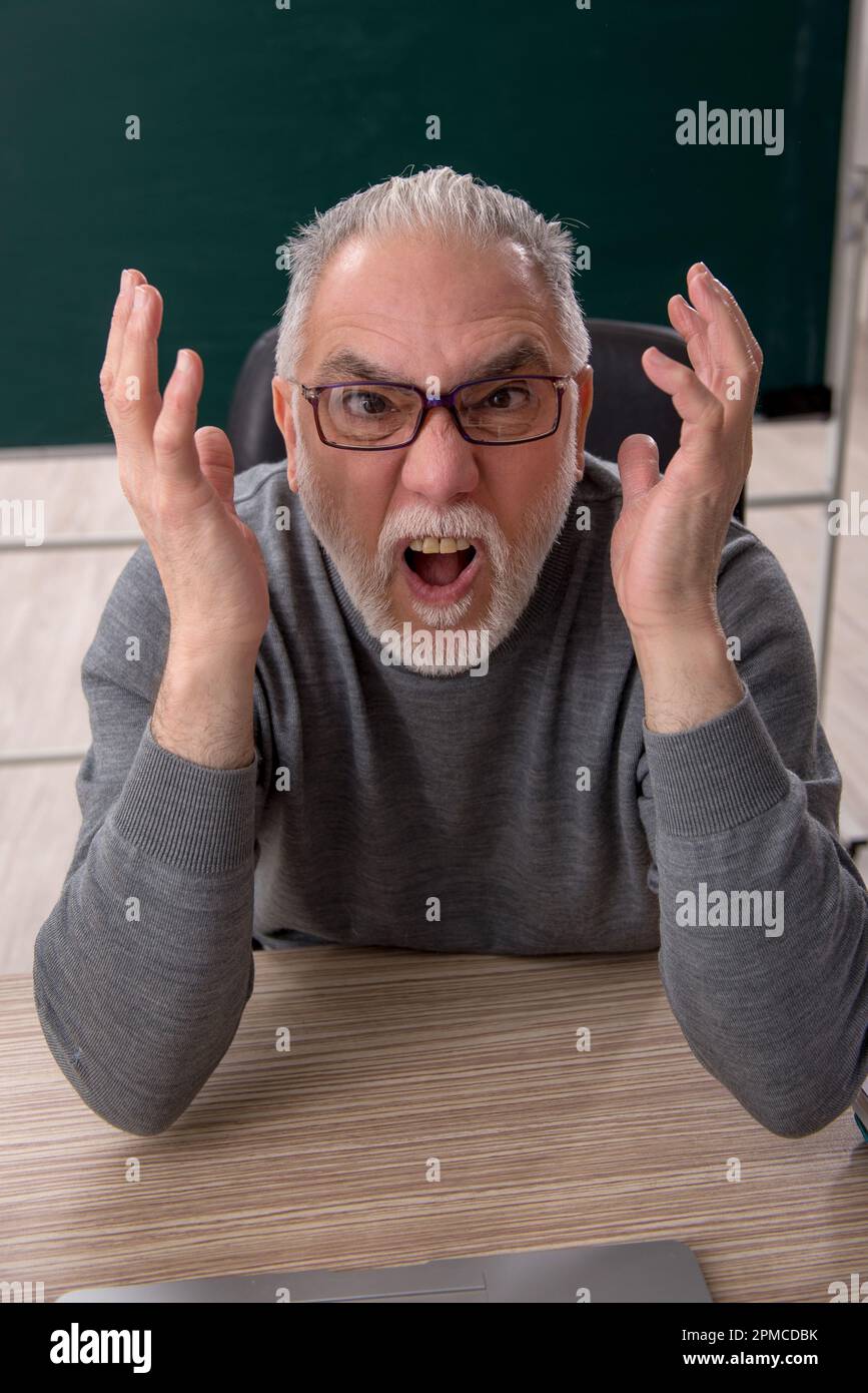 Old teacher in the classroom Stock Photo - Alamy