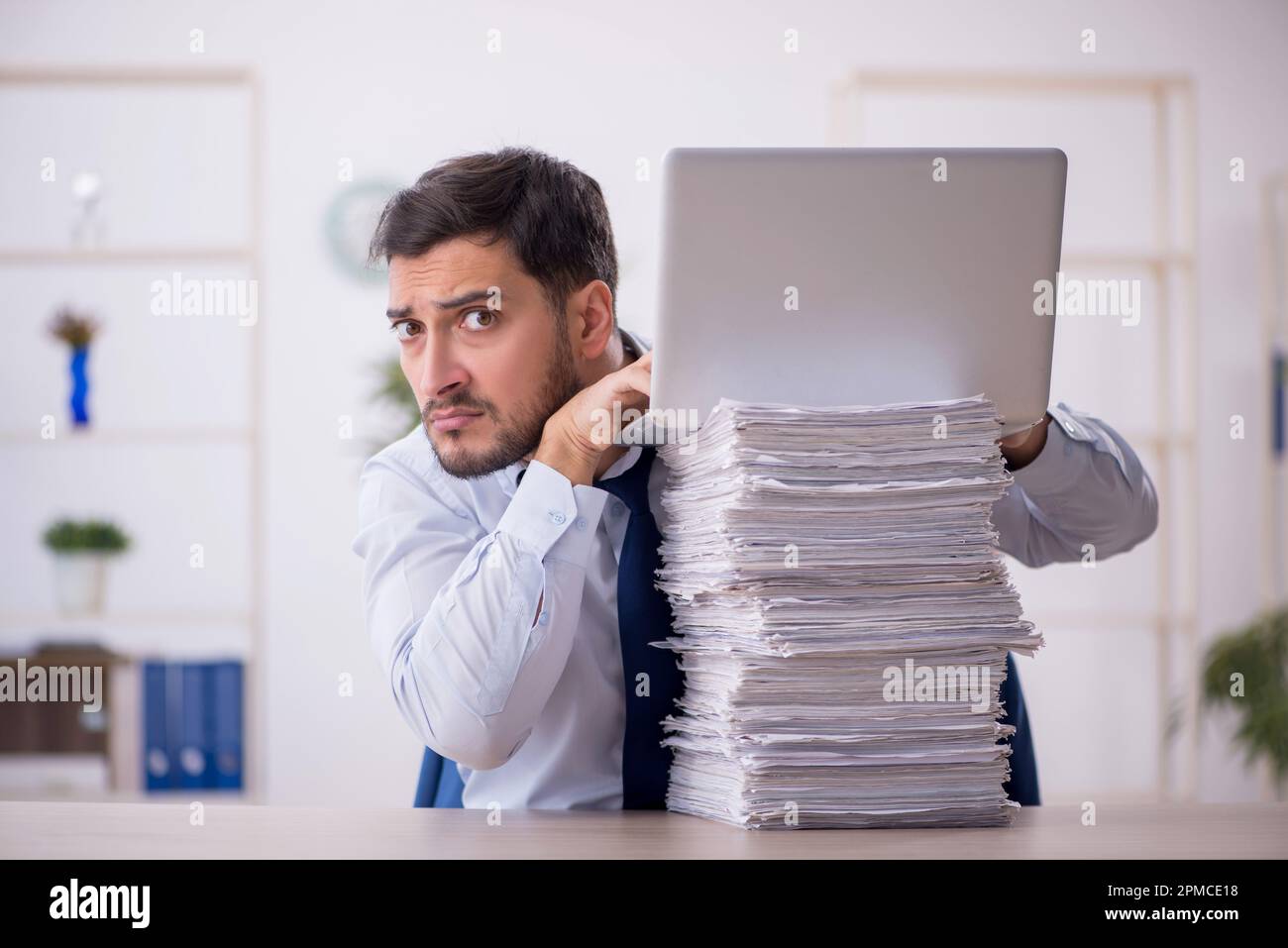 Young employee and too much work in the office Stock Photo - Alamy