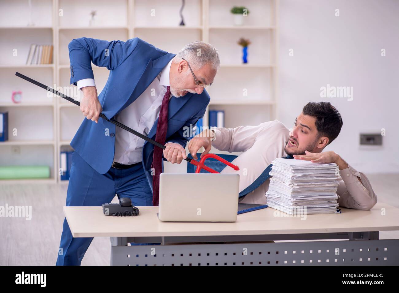 Old boss and young employee in bullying concept Stock Photo - Alamy