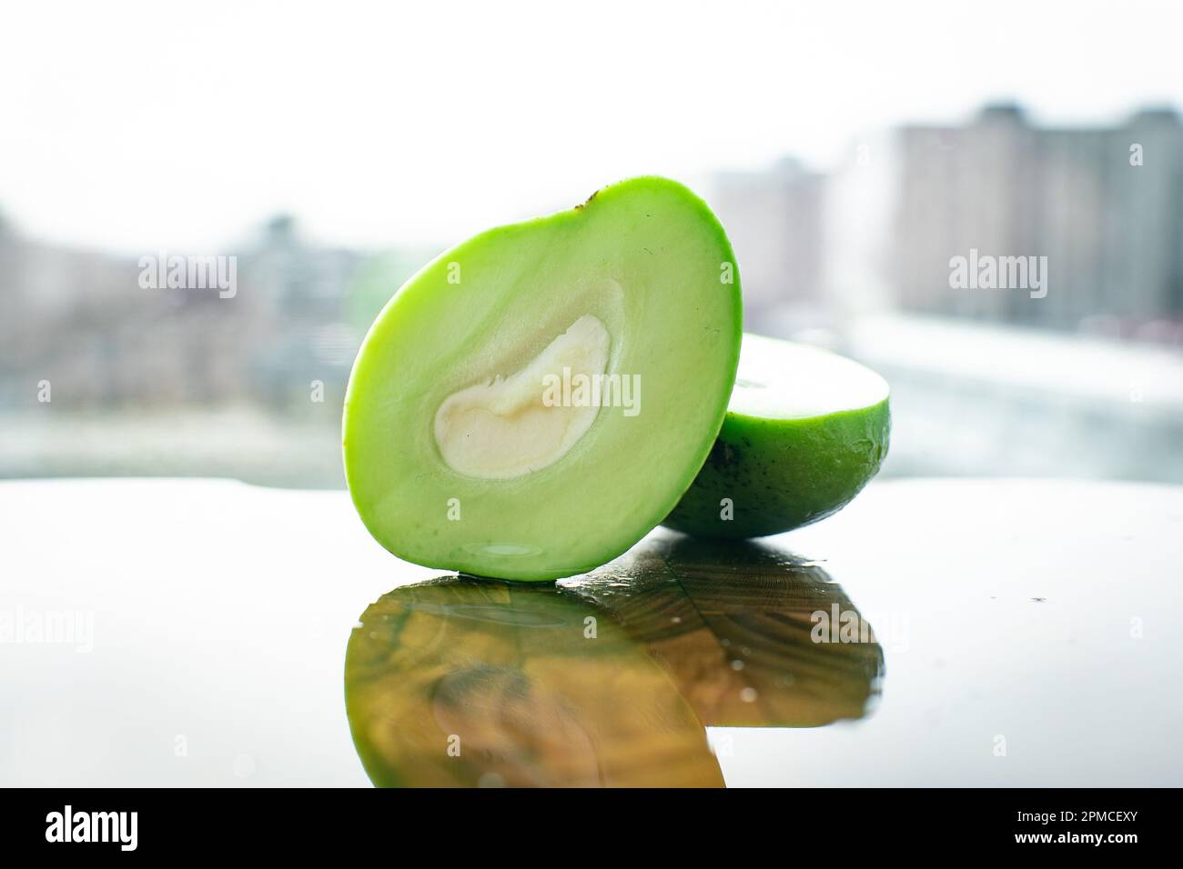 Green mango or baby mango is a small round mango with a vibrant emerald ...