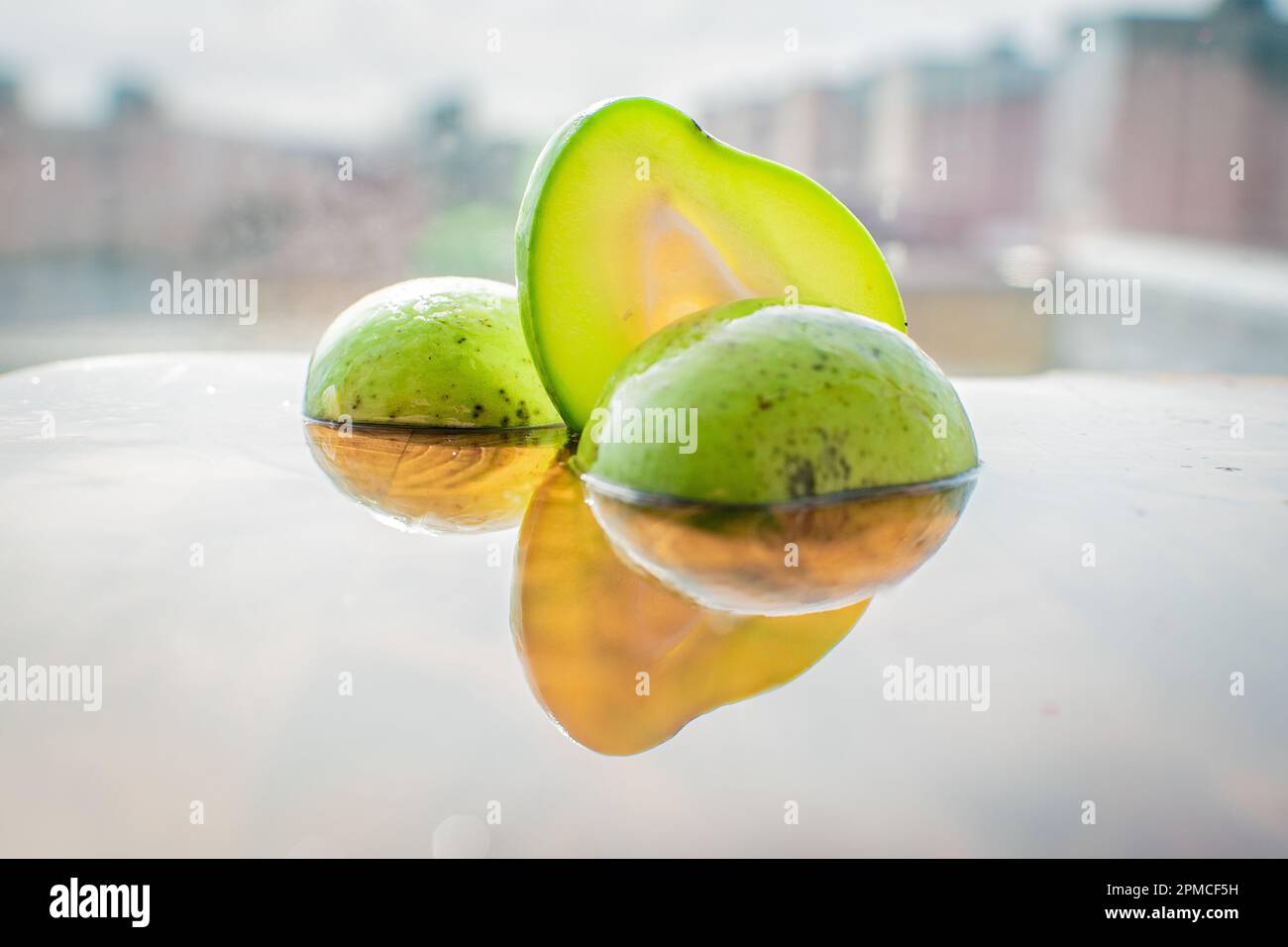 Green mango or baby mango is a small round mango with a vibrant emerald ...