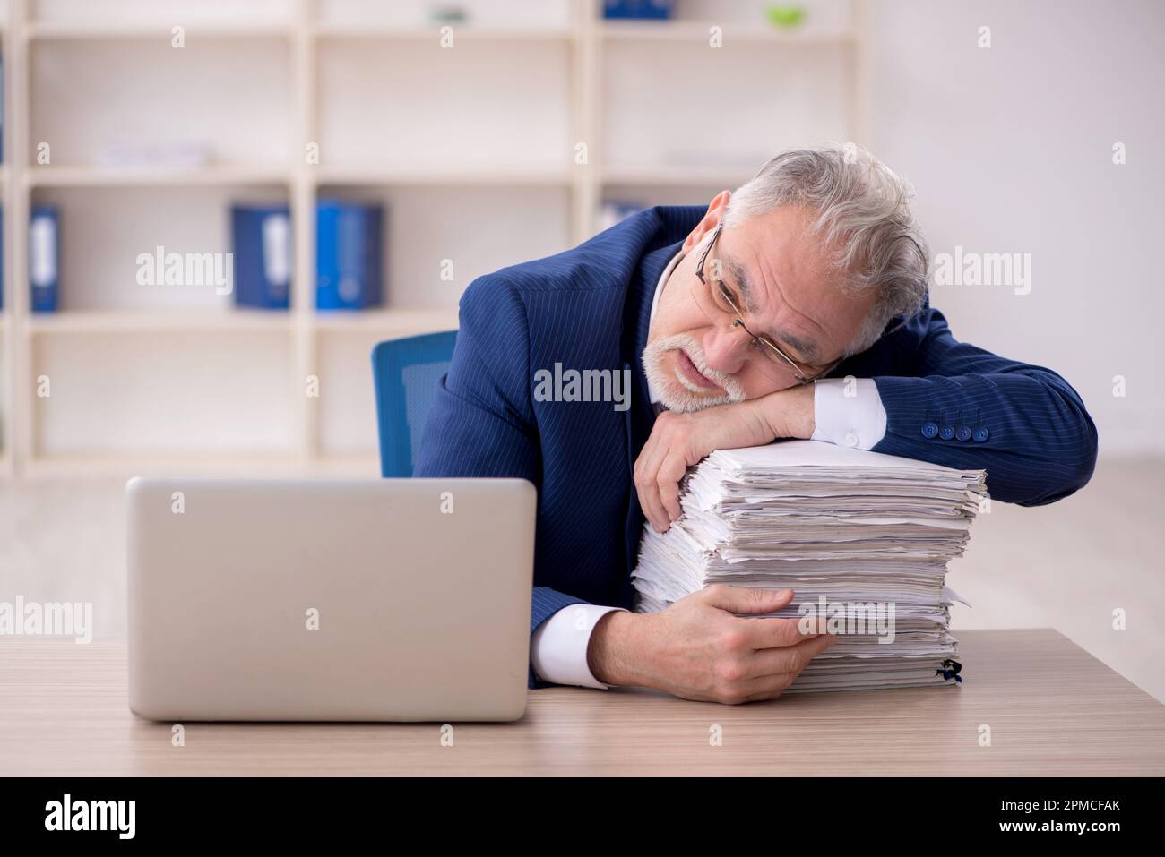 Old employee unhappy with excessive work at workplace Stock Photo - Alamy
