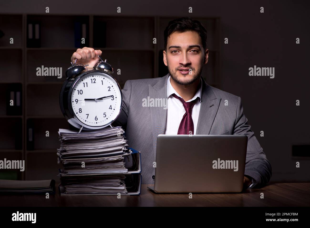 Young employee working late at workplace Stock Photo - Alamy