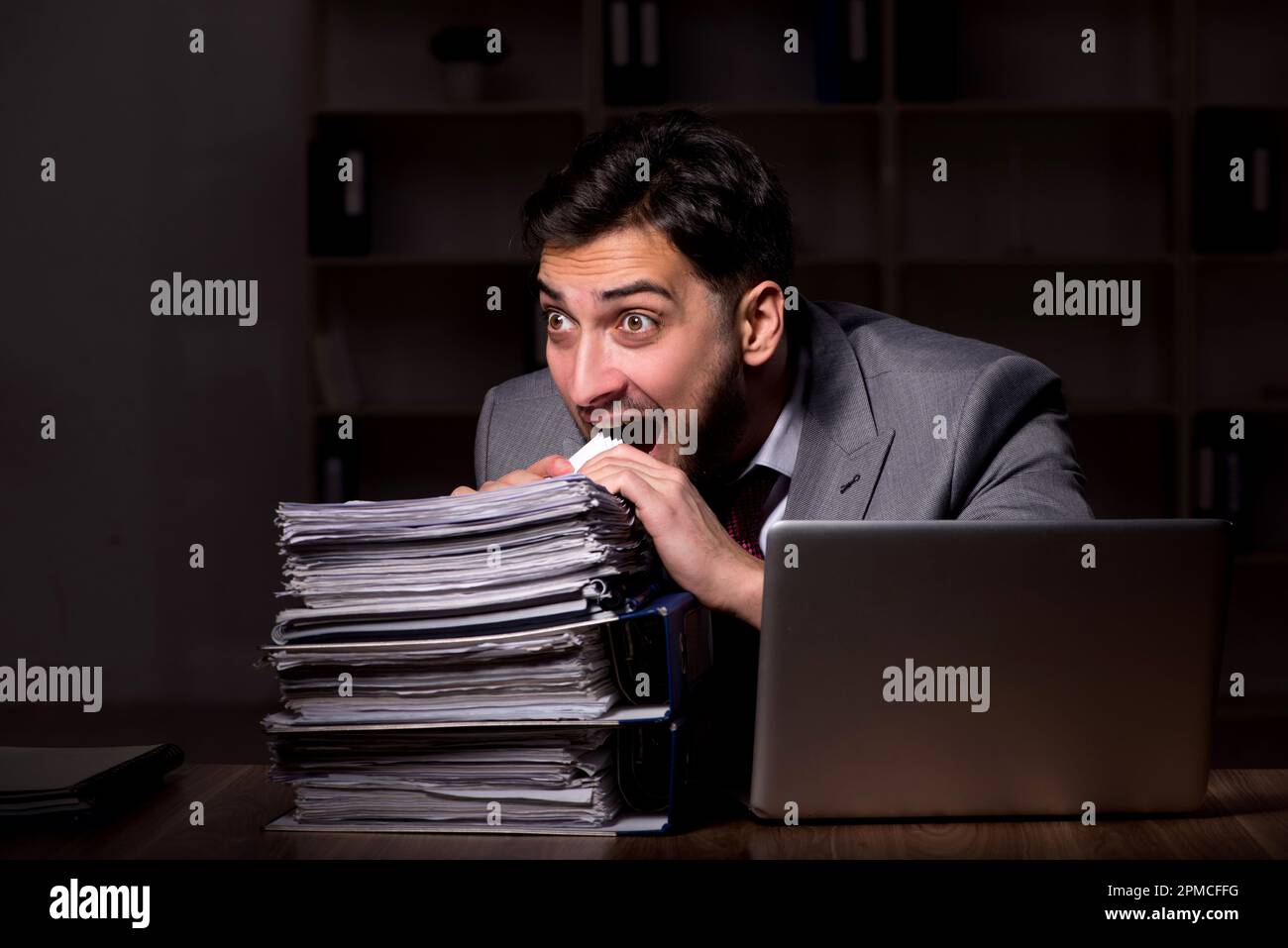 Young employee working late at workplace Stock Photo - Alamy