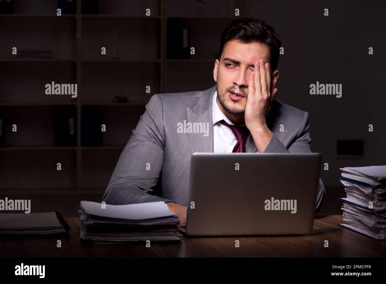 Young employee working late at workplace Stock Photo - Alamy