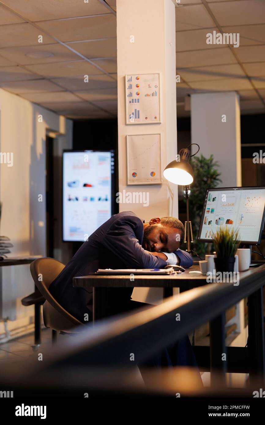 Hardworking entrepreneur falling asleep on table in startup office ...