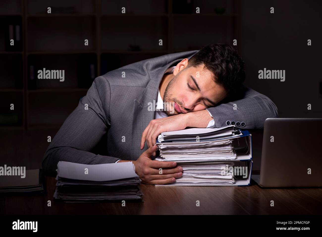 Young employee working late at workplace Stock Photo - Alamy