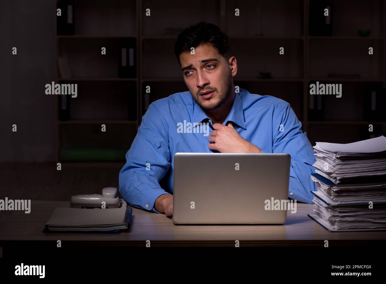 Young employee working late at workplace Stock Photo - Alamy