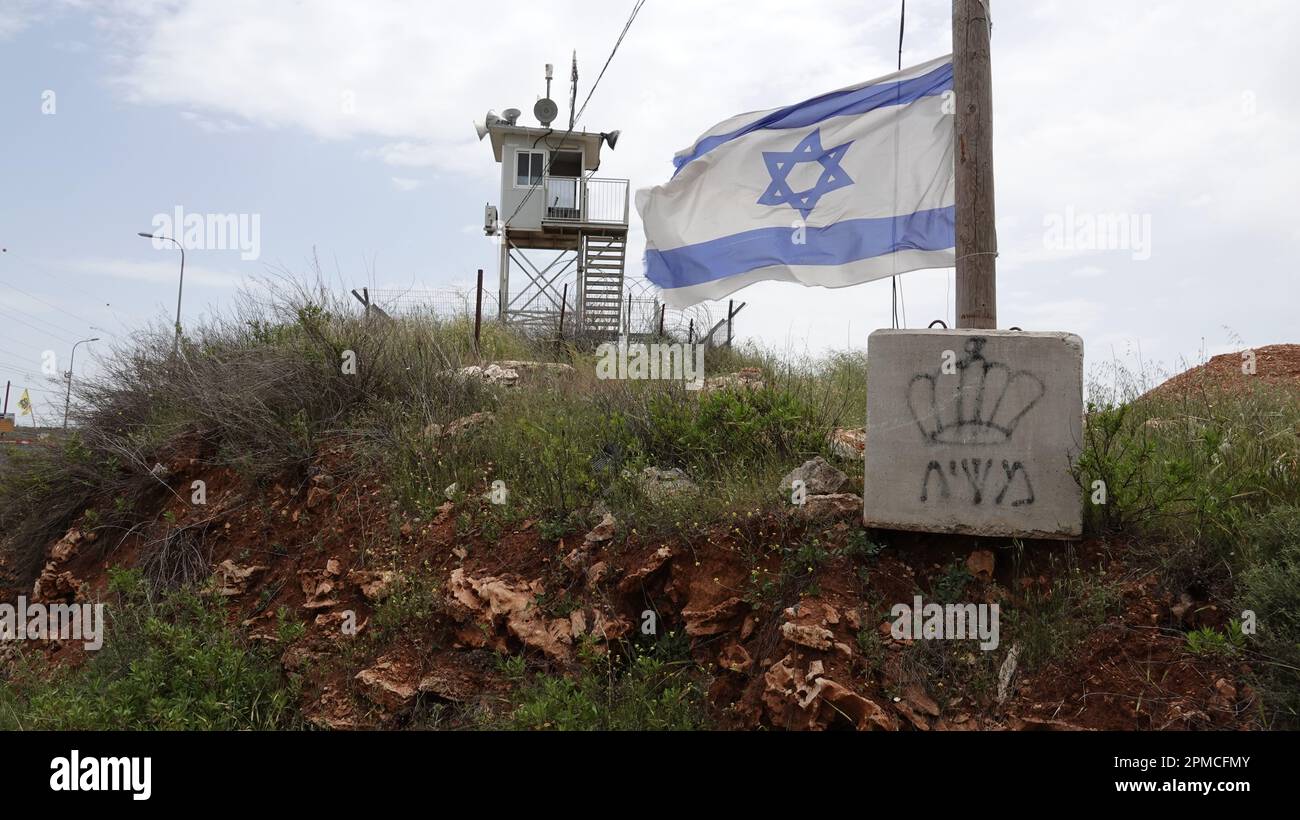 The Israeli national flag flutters in the wind next to a military ...