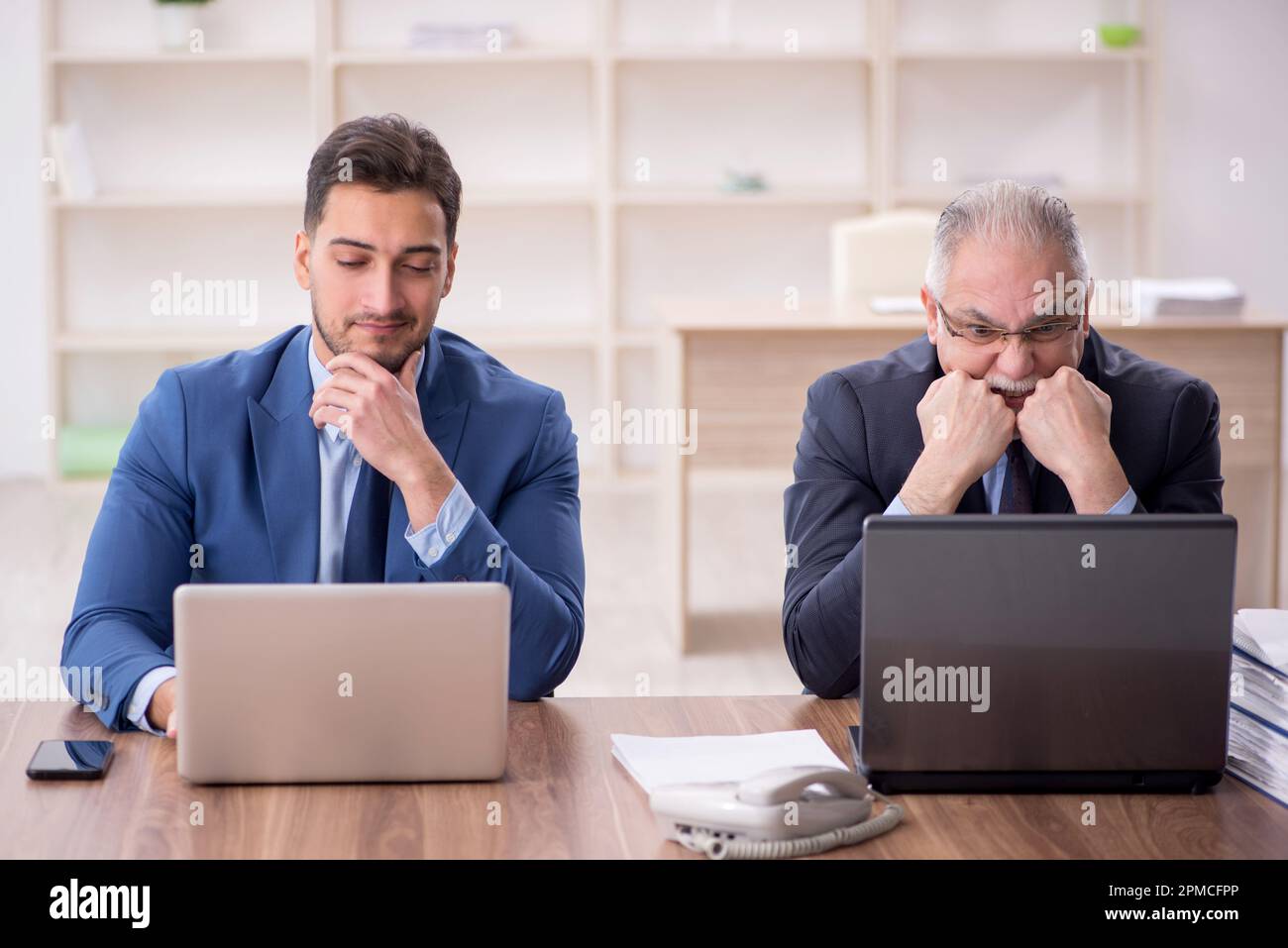 Two employees sitting at workplace Stock Photo - Alamy