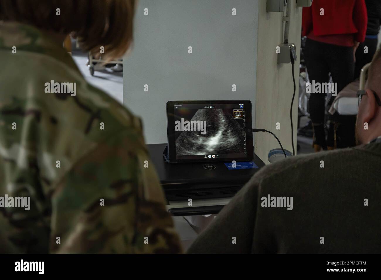 Military doctors look at the screen of the ultrasound diagnostic ...