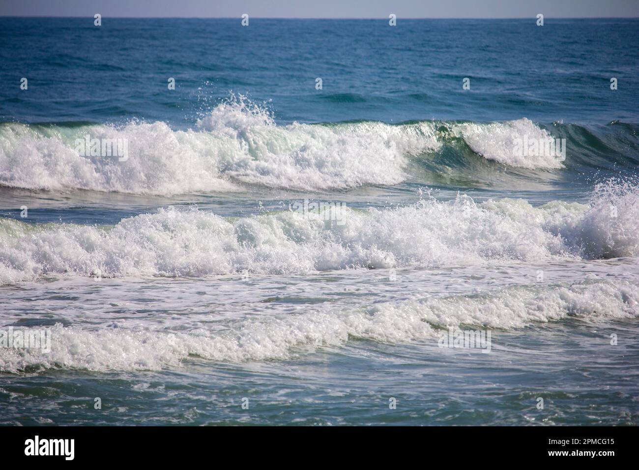 A tranquil ocean view with rolling waves lapping the shoreline Stock ...