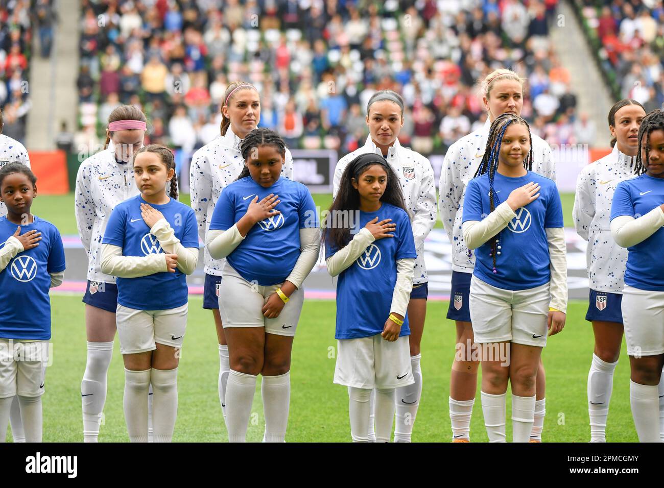 USA players line up with local girls to say the Pledge of Allegiance ...