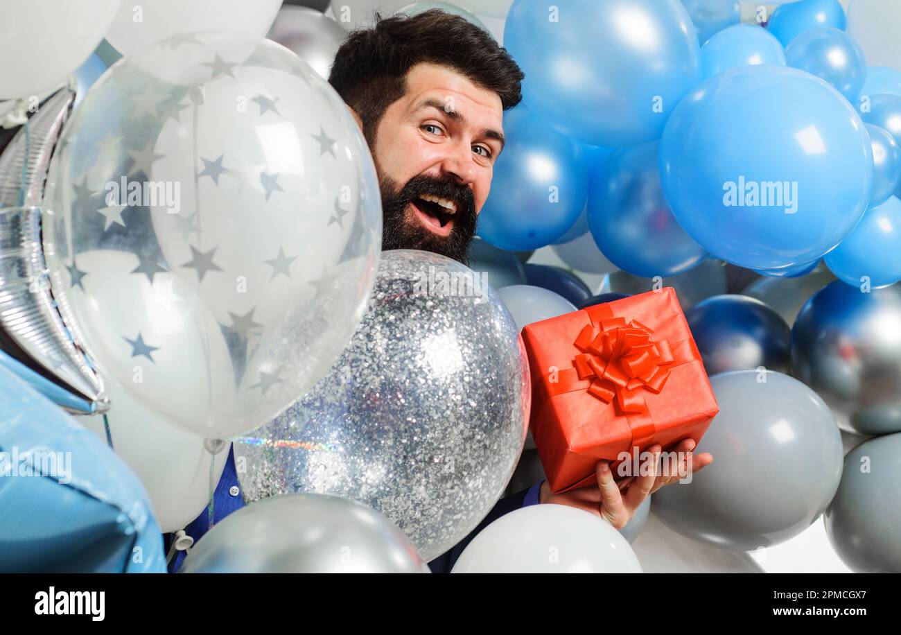 Festive event or birthday party. Happy man with helium balloons holds ...