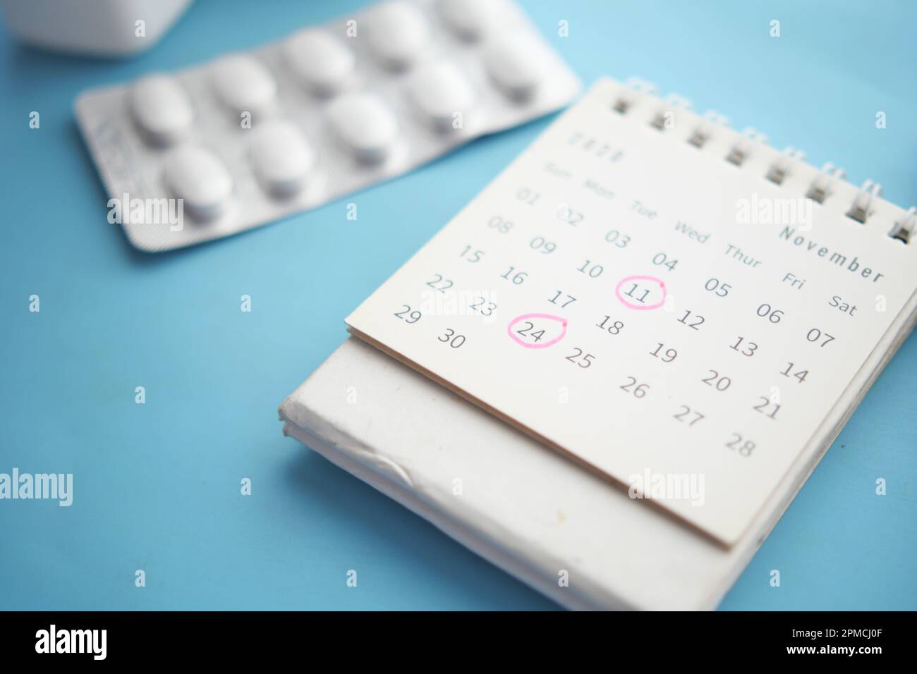 stethoscope, medical pill container and calendar on color background ...