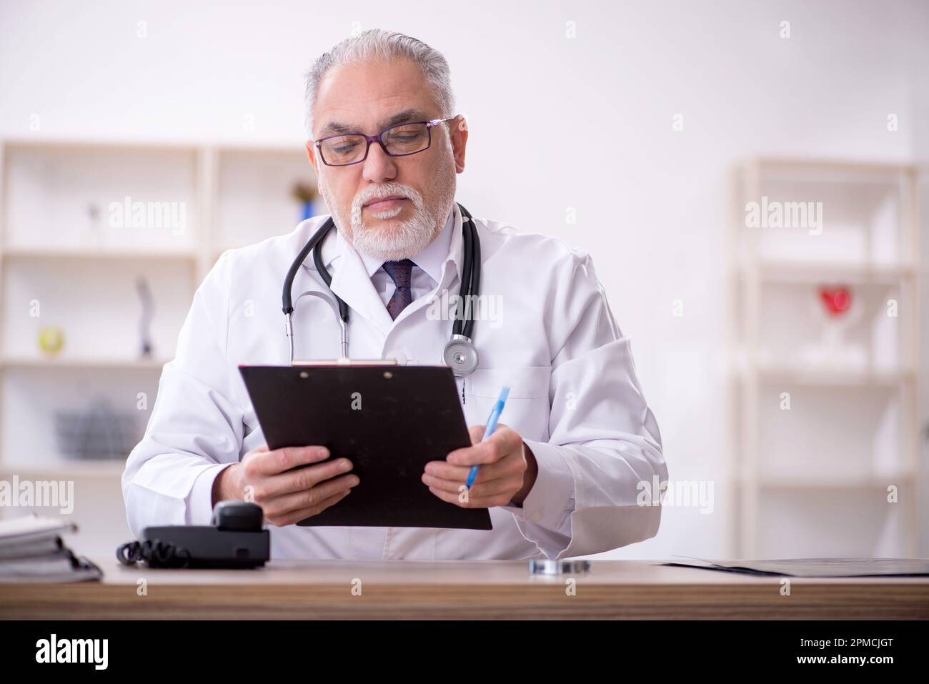 Old doctor working in the clinic Stock Photo - Alamy