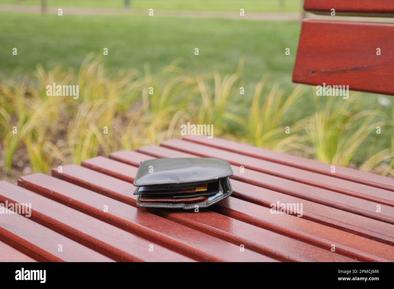 left wallet on a bench in the park Stock Photo - Alamy