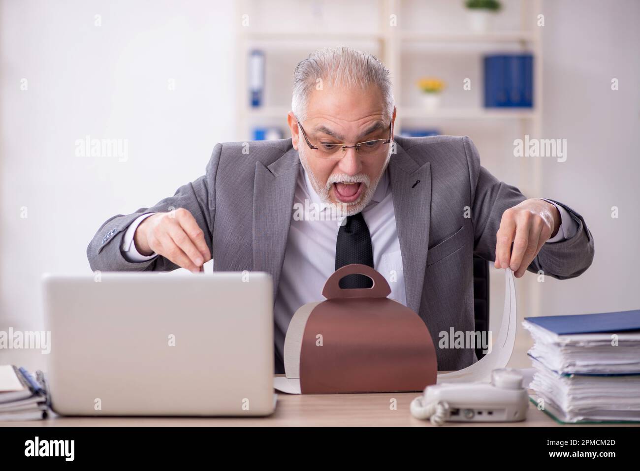 Old businessman employee eating cake at workplace Stock Photo - Alamy