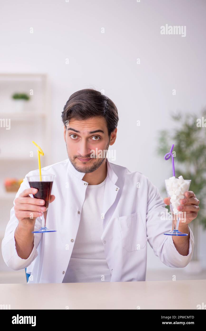 Young chemist examining soft drink at the lab Stock Photo - Alamy