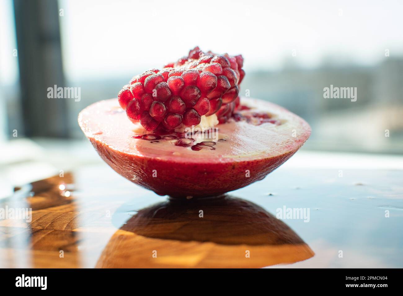 Close-up of pomegranate with its vibrant red color. The small pods are ...