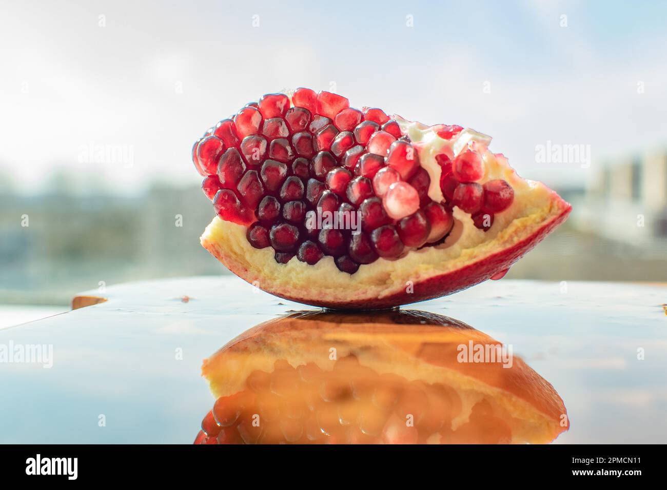 Close-up of pomegranate with its vibrant red color. The small pods are ...