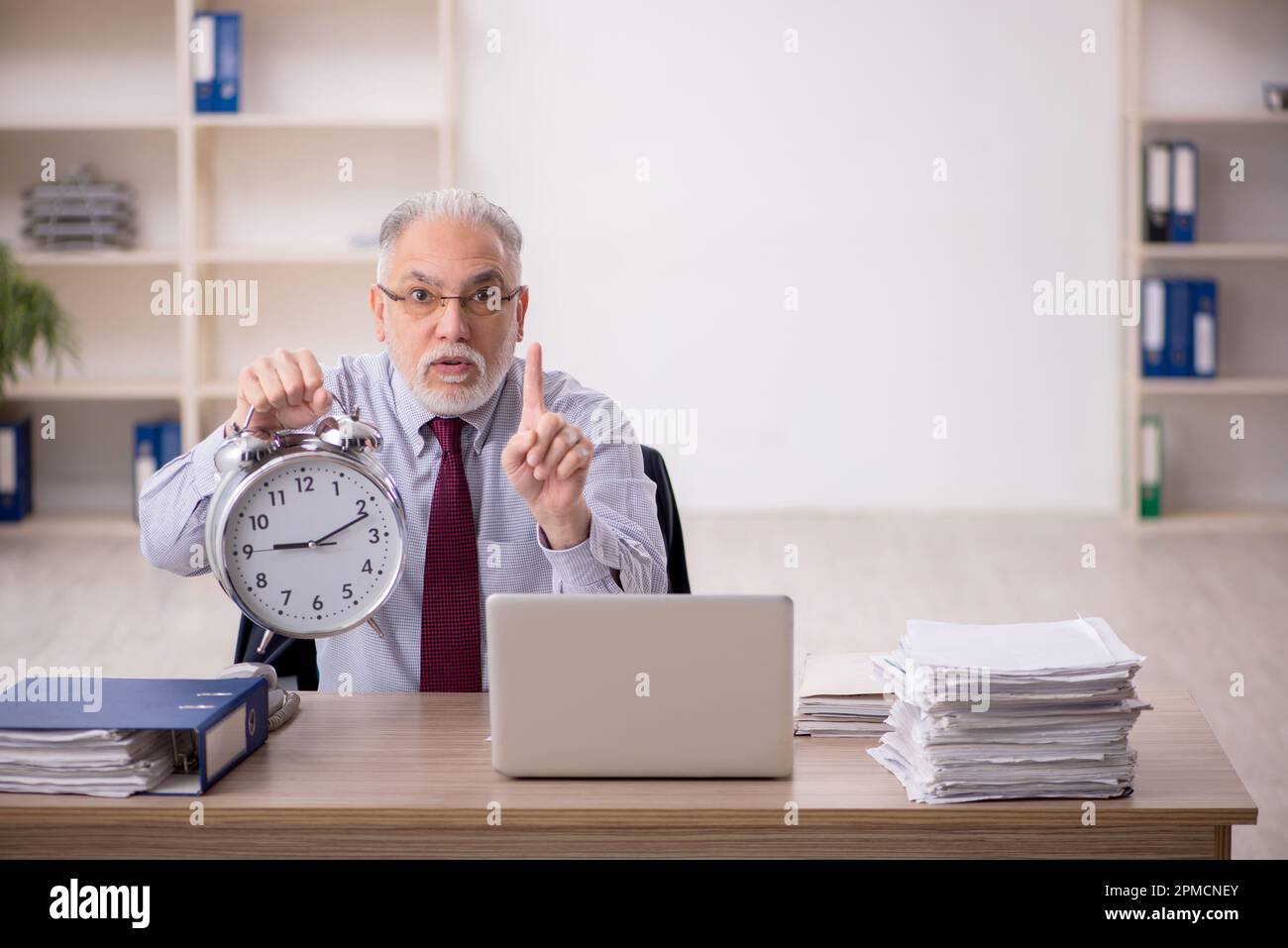 Old boss employee in time management concept Stock Photo - Alamy