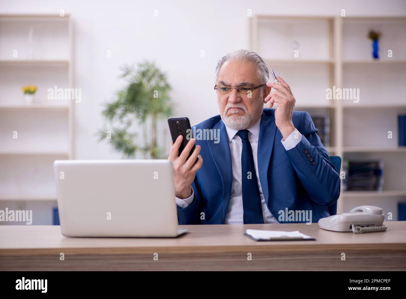 Old boss working in the office Stock Photo - Alamy