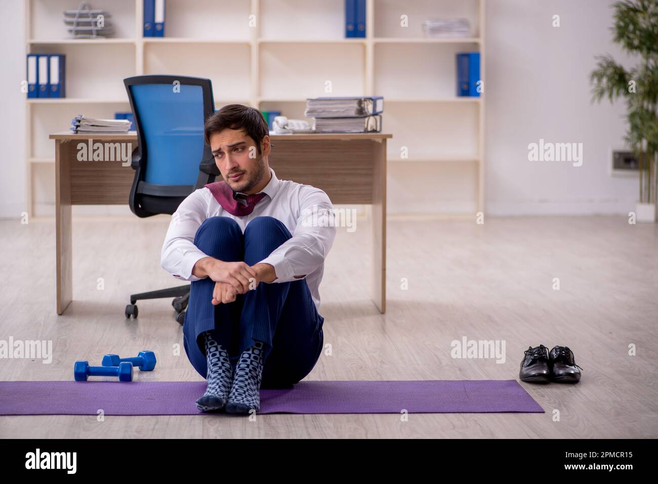 Young employee doing sport exercises during break Stock Photo - Alamy