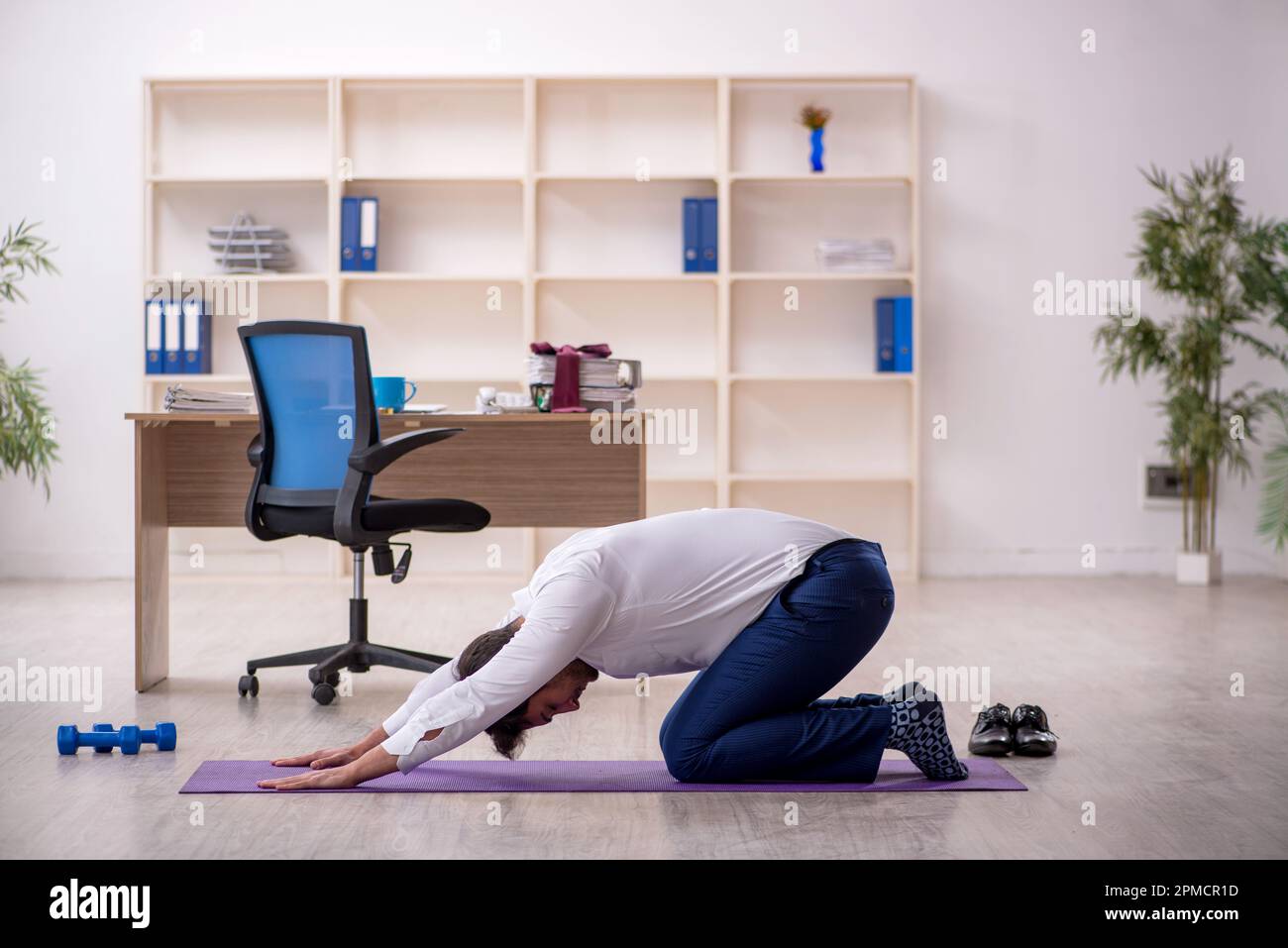 Young employee doing sport exercises during break Stock Photo - Alamy
