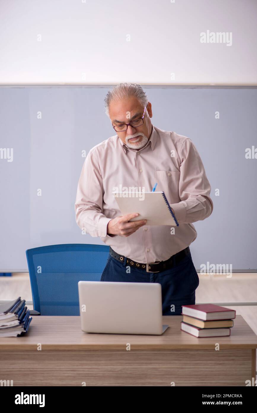 Old teacher in front of whiteboard Stock Photo - Alamy