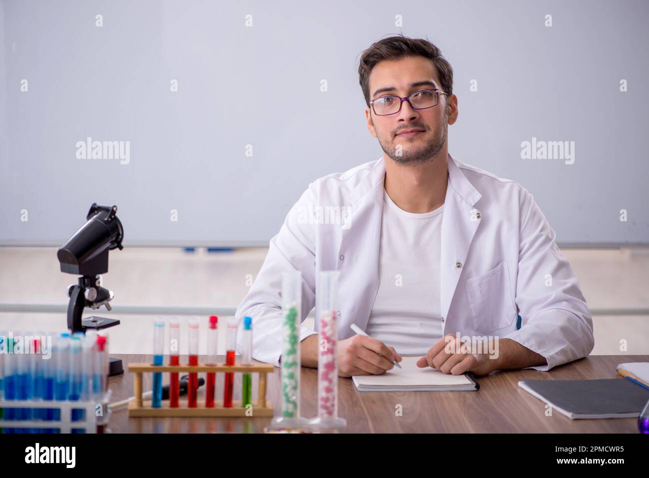 Young chemist in front of white board Stock Photo - Alamy