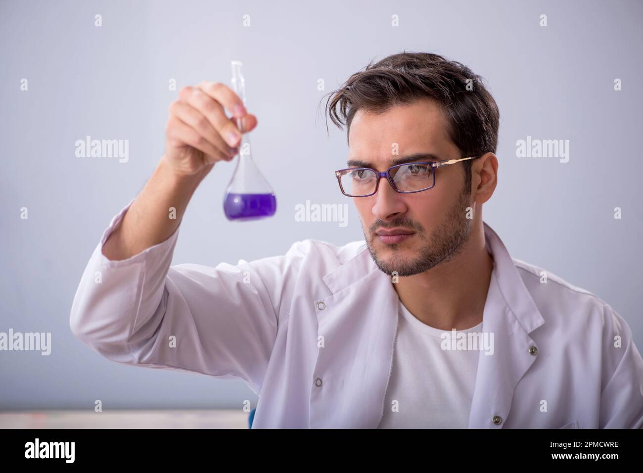 Young chemist in front of white board Stock Photo - Alamy