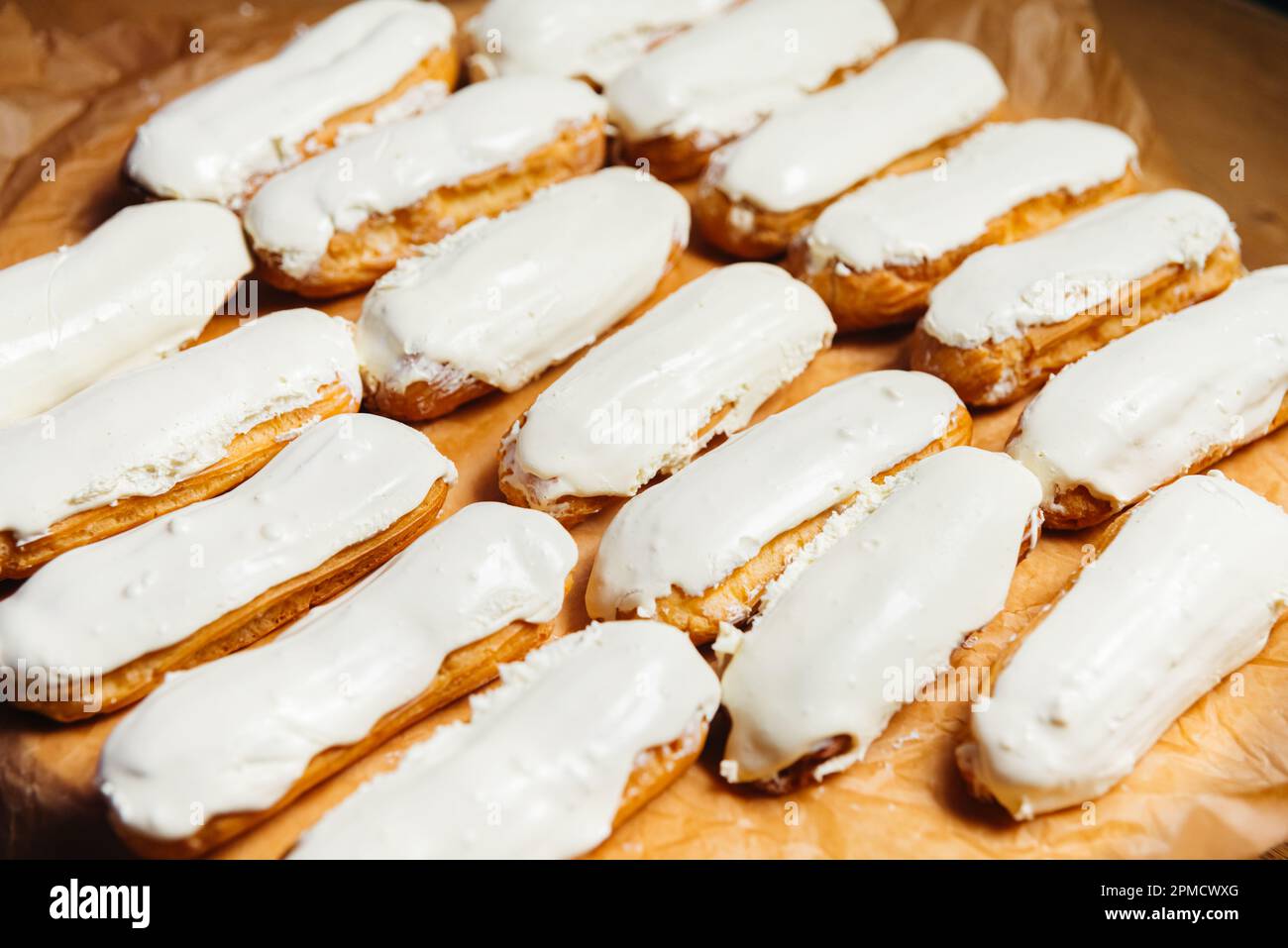 Delicious eclairs with white frosting on a craft paper Stock Photo - Alamy