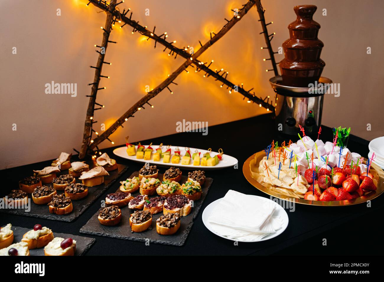 Buffet with various types of snacks and appetizers. Canapes of strawberries, marshmallows ...