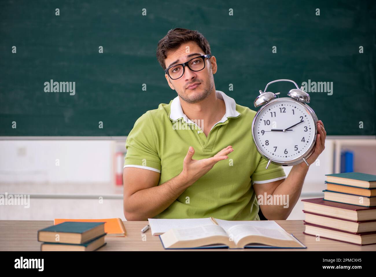 Young student in the classroom in time management concept Stock Photo ...