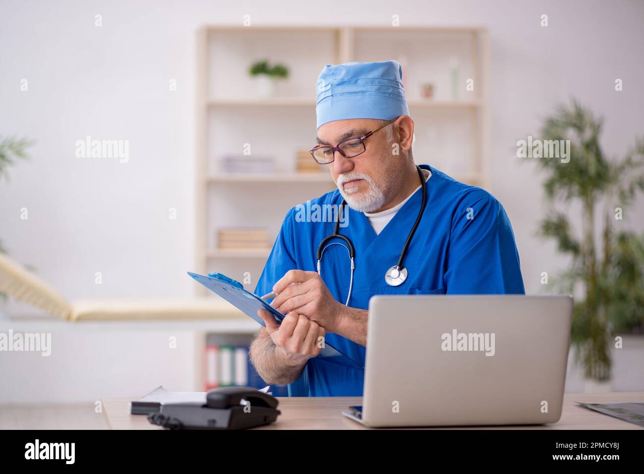 Old doctor working in the clinic Stock Photo - Alamy