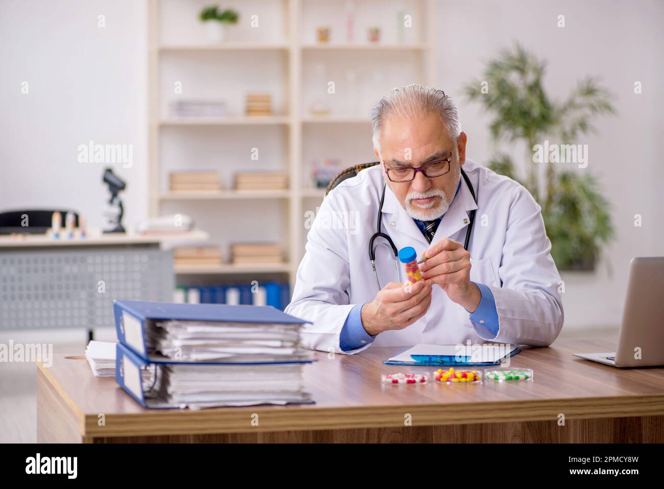 Old doctor pharmacist in drugs synthesis concept Stock Photo - Alamy