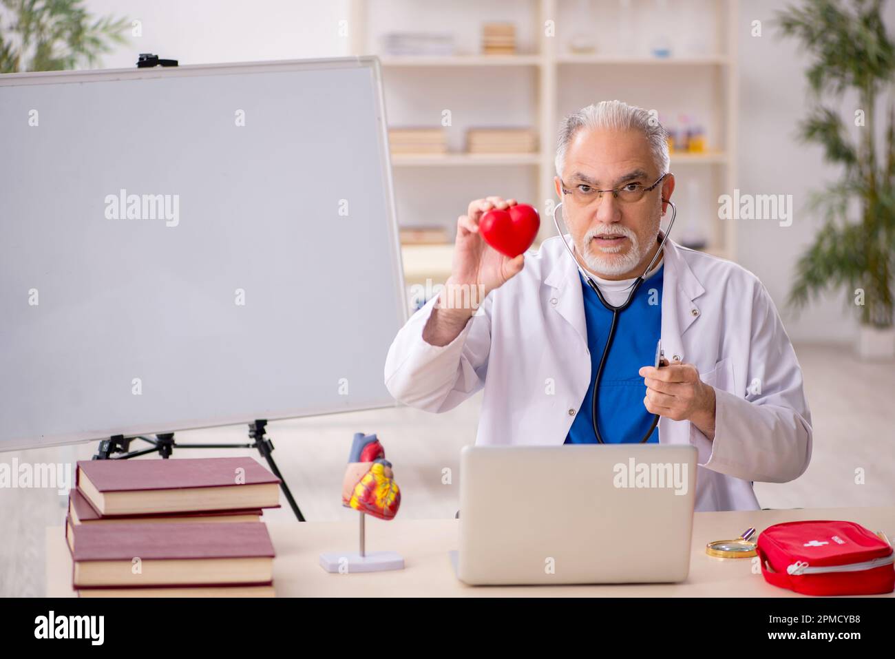 Old doctor cardiologist working at the hospital Stock Photo - Alamy