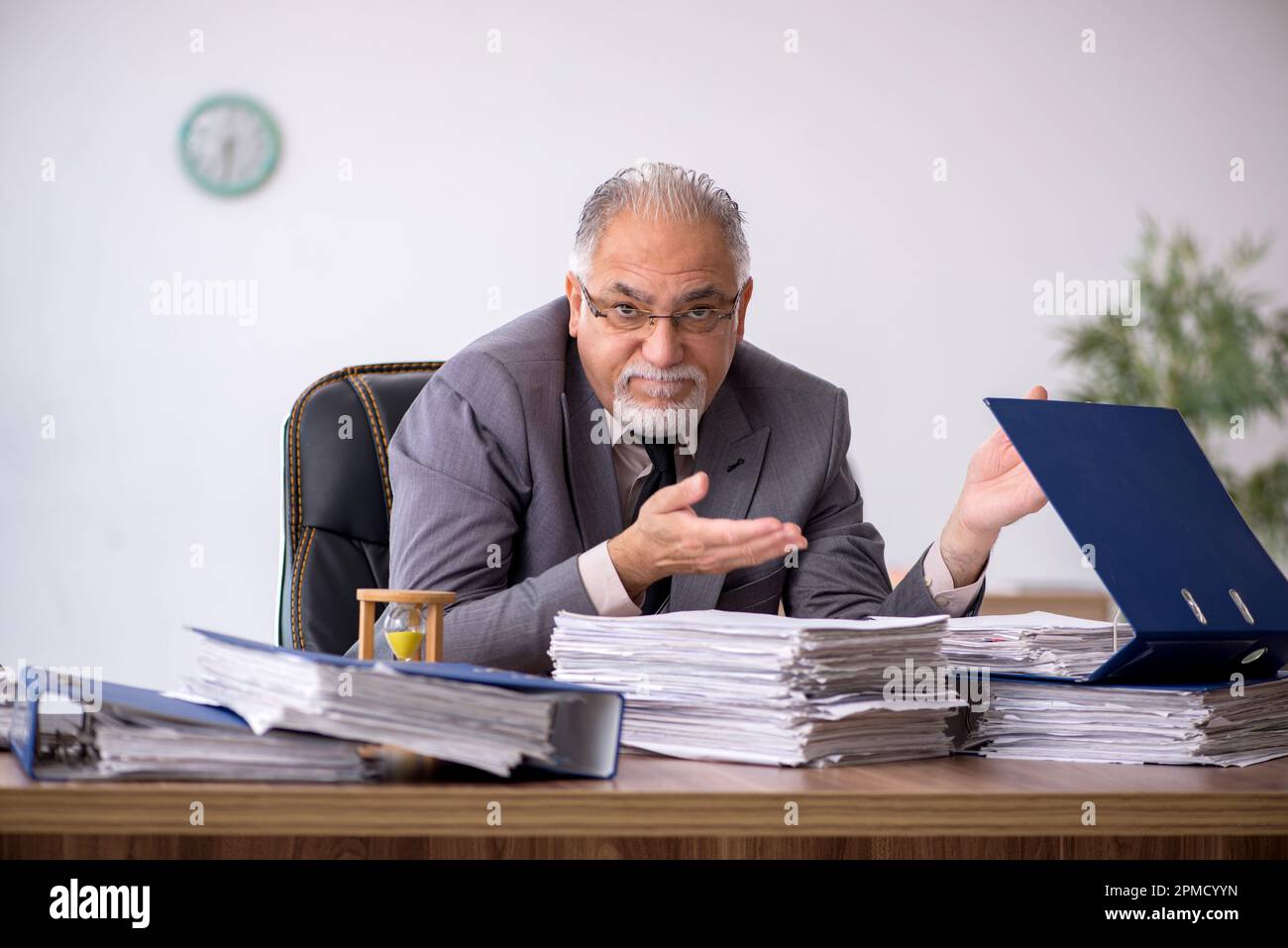 Old male boss in time management concept Stock Photo - Alamy