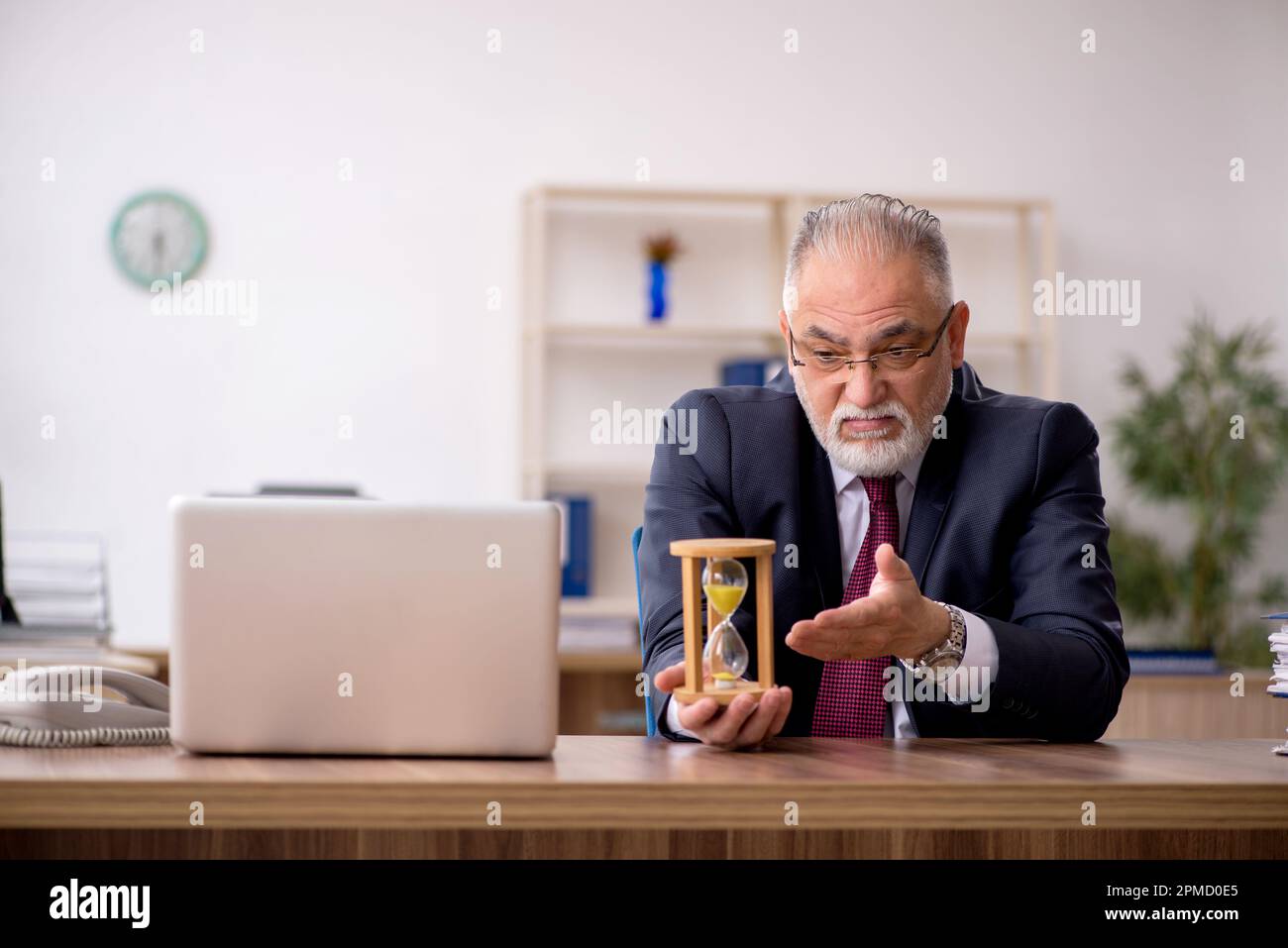 Old employee in time management concept Stock Photo - Alamy