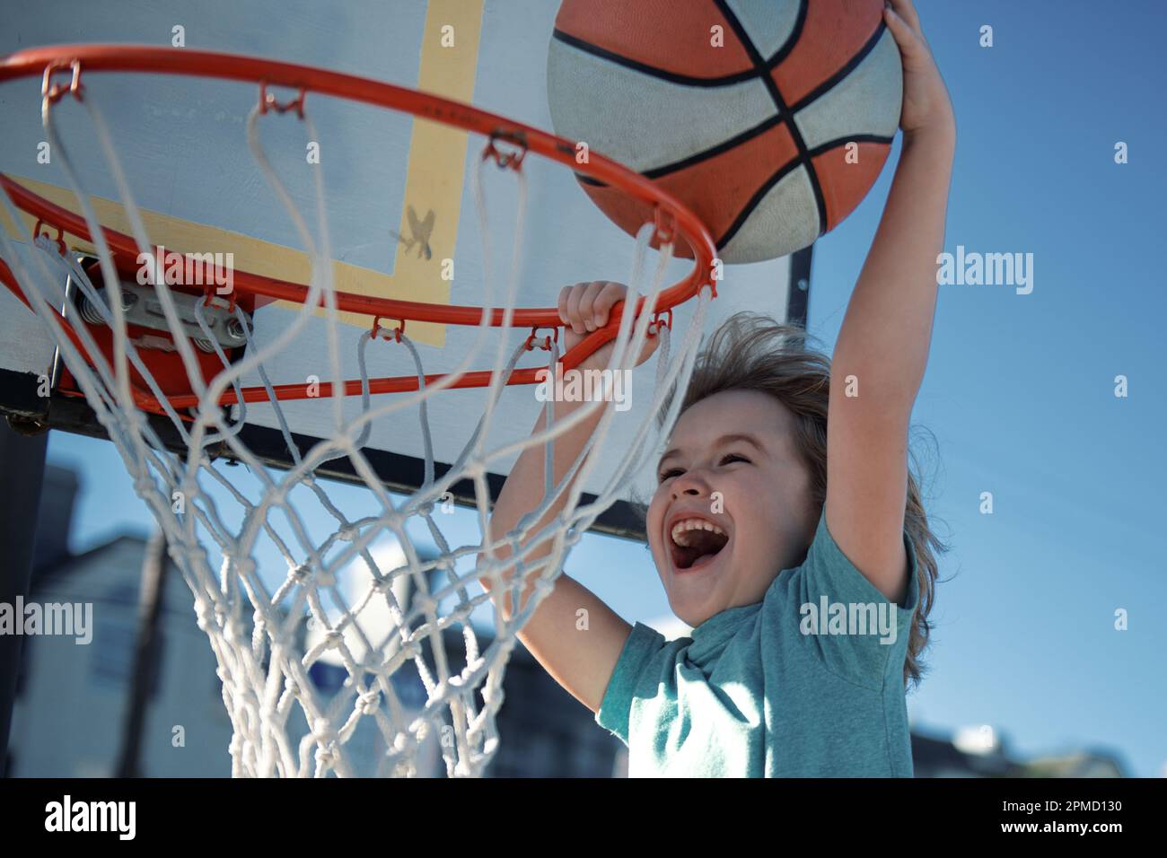 Closeup face of kid basketball player making slam dunk during ...