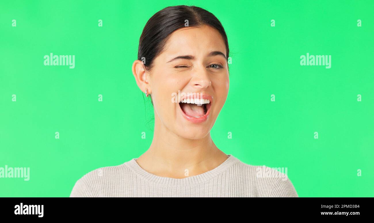 Happy, woman and winking face on green screen, studio and color ...