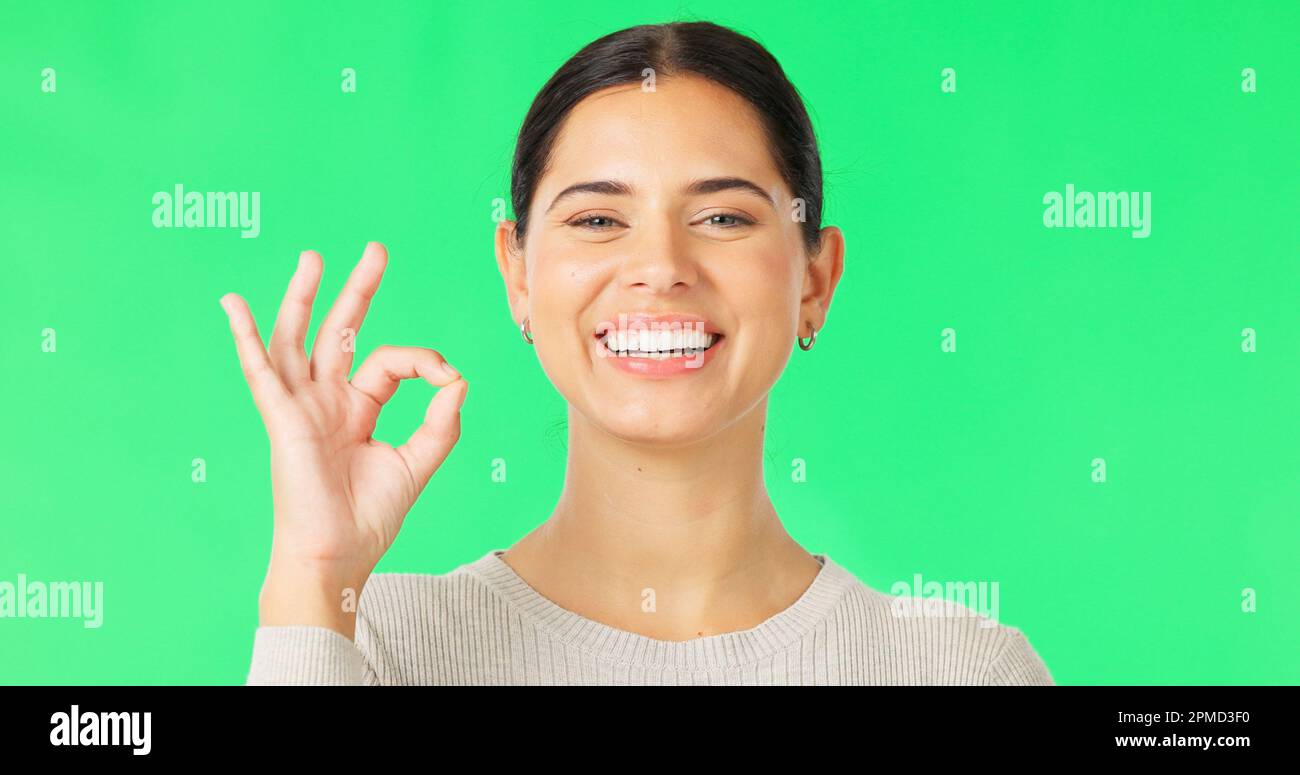 Face, green screen and woman with ok sign, smile and approval against a ...