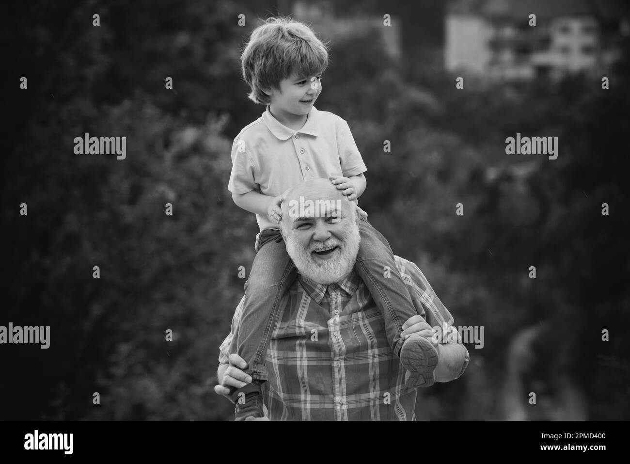 Little boy and grandfather raising hands over sunset sky enjoying life ...