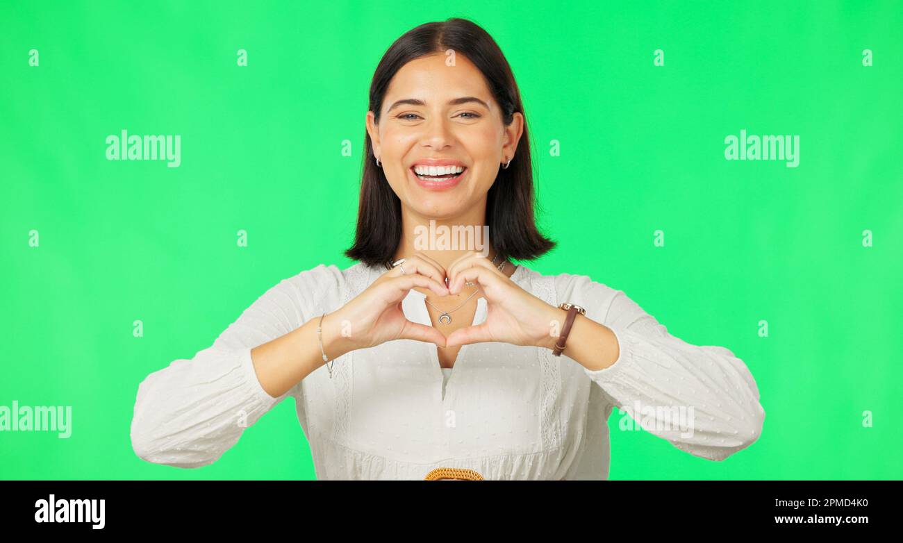 Heart, hands and face of woman smile on green screen, studio or happy ...