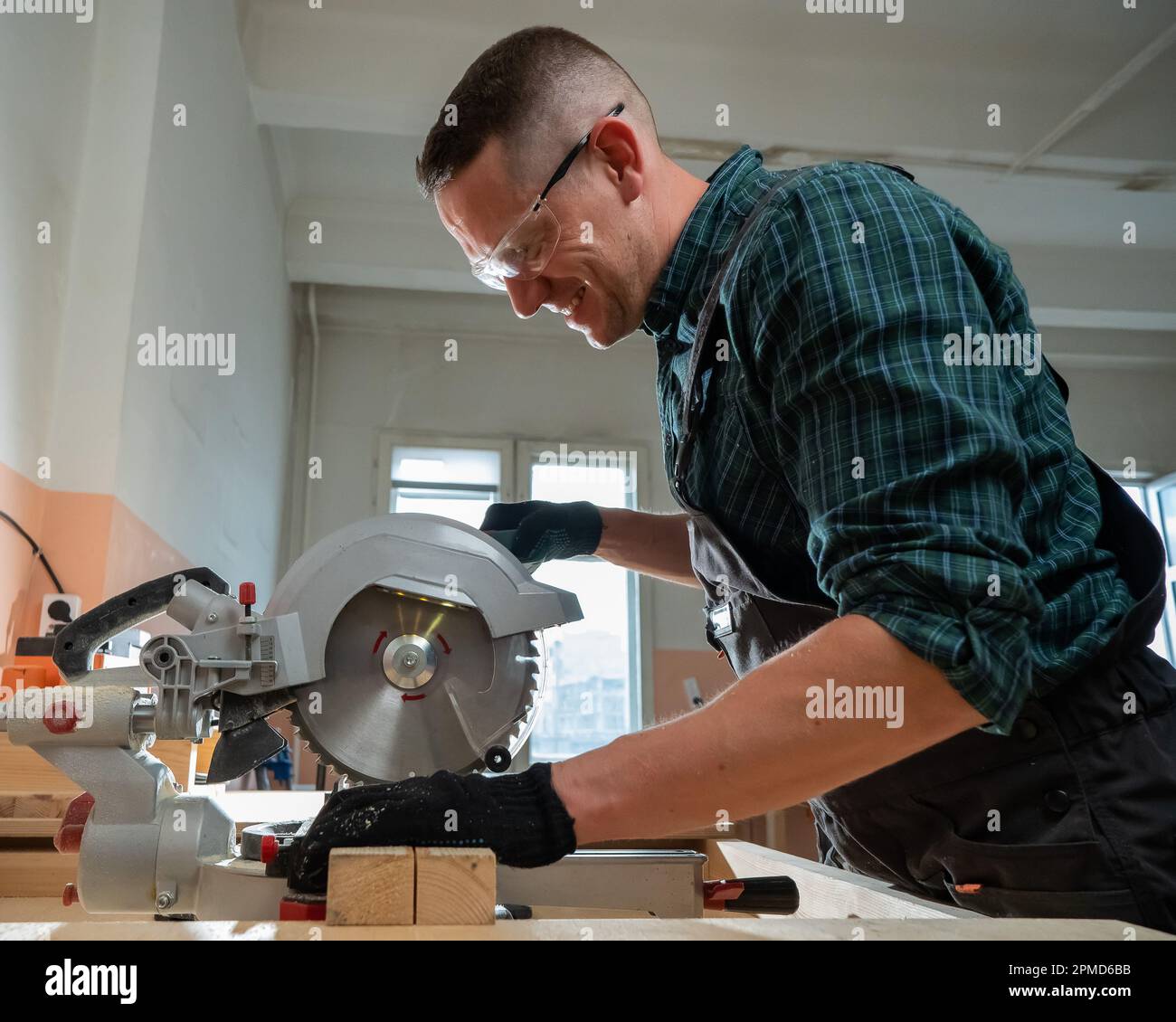 Master cuts the board with a circular saw in the workshop Stock Photo ...