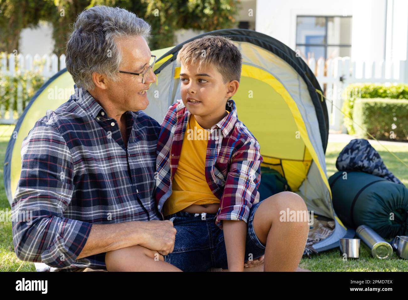 Caucasian grandfather and grandson talking while camping in yard Stock ...